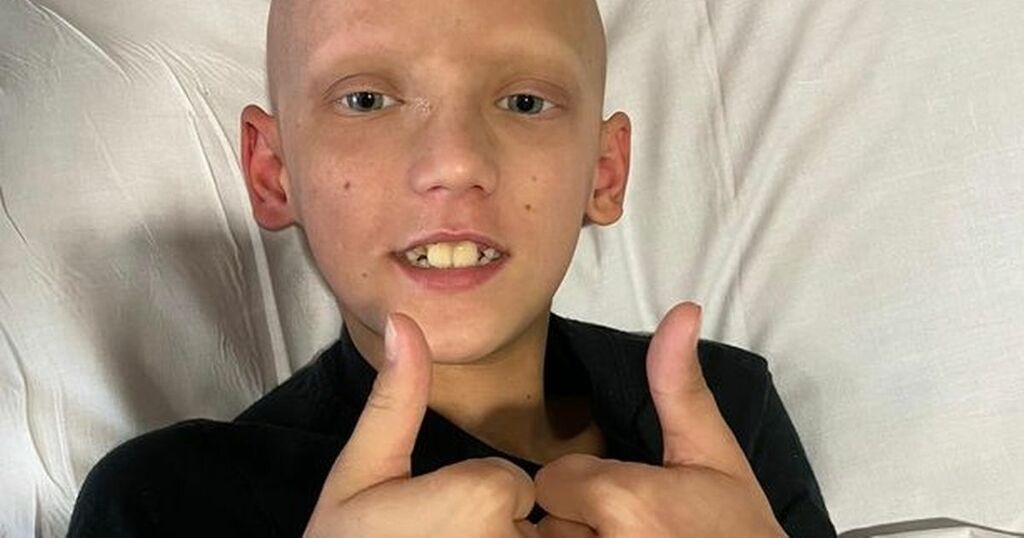 Brave boy, 8, gives thumbs up after treatment as…