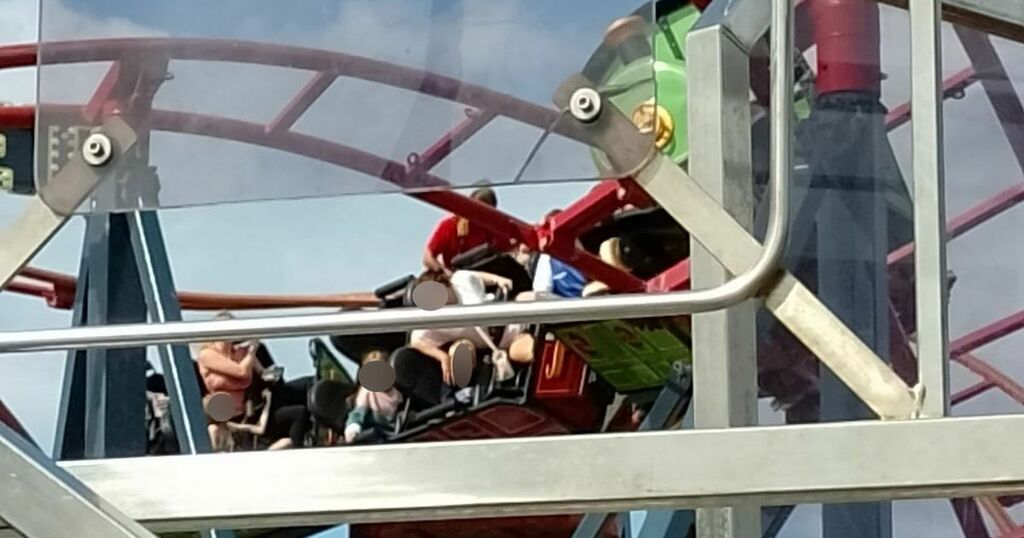 Parents cling to their children at theme park as…