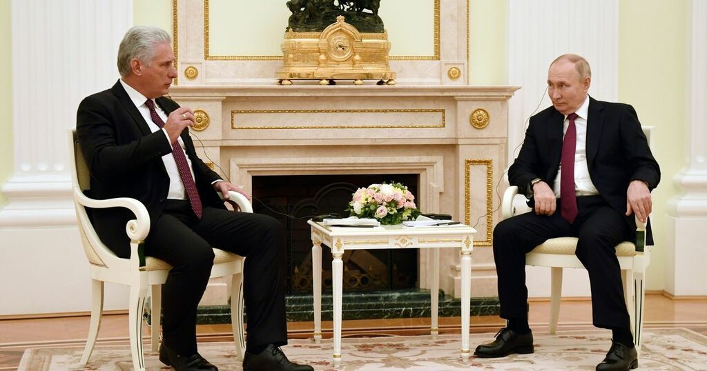 Puffy faced Vladimir Putin’s hand turns purple as he…