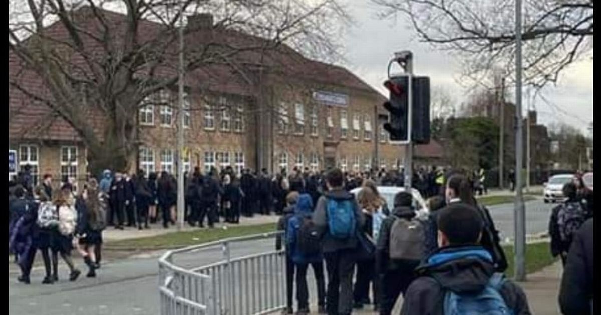 Long queues form at school as each pupil checked at…