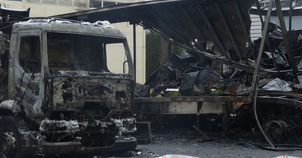 Charred and tattered remains of HGVs at industrial…
