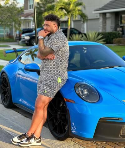 Omar Narváez Strikes A Pose Next To A Blue Car