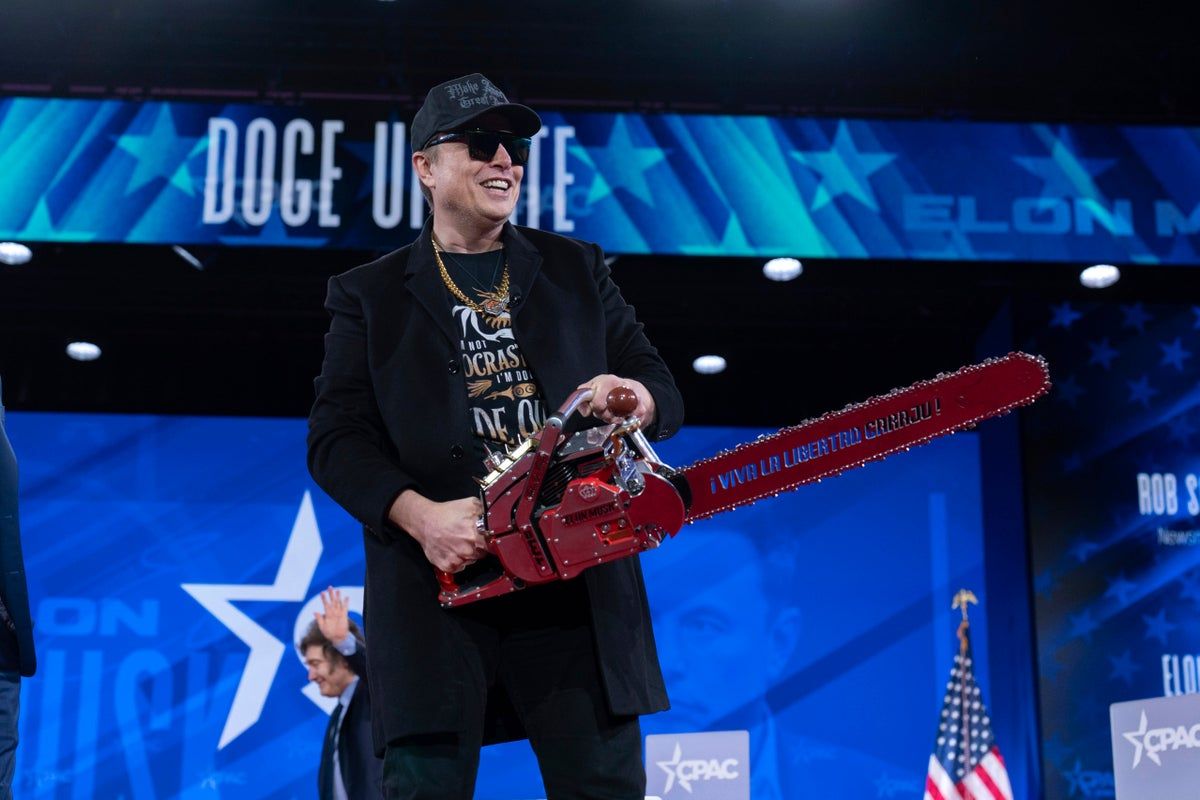 Watch: Elon Musk waves chainsaw on stage in bizarre…