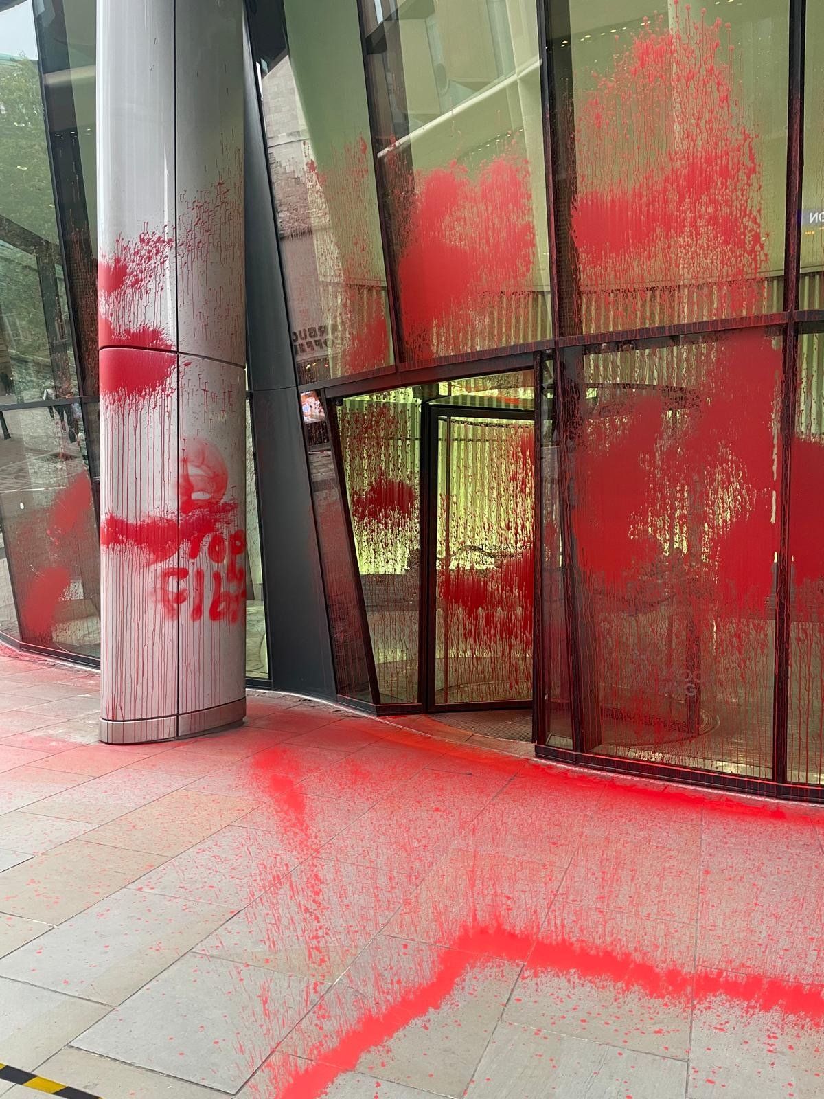 Windows smashed and red paint sprayed on building in…