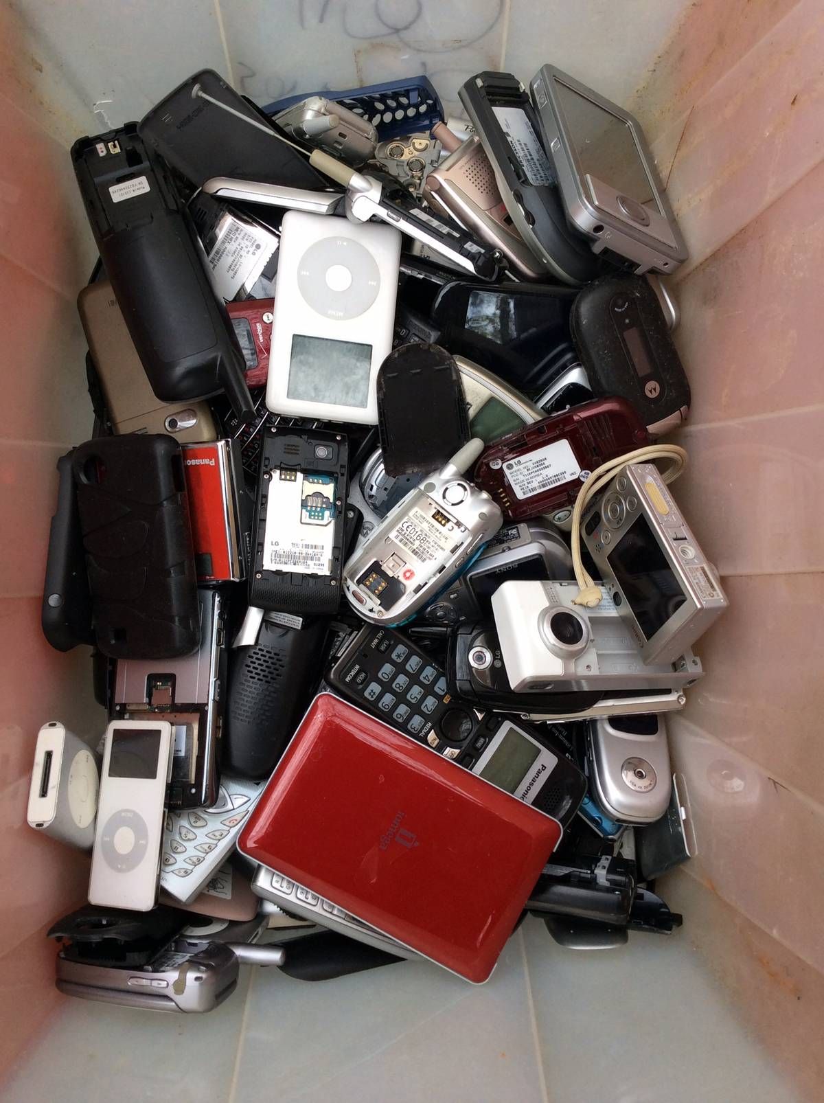 Discarded phones, computers and electronics behind…