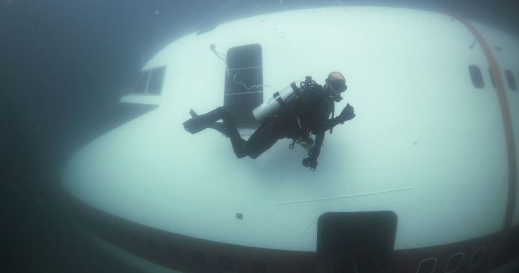 Diver swims through sunken Boeing 747 exploring the…